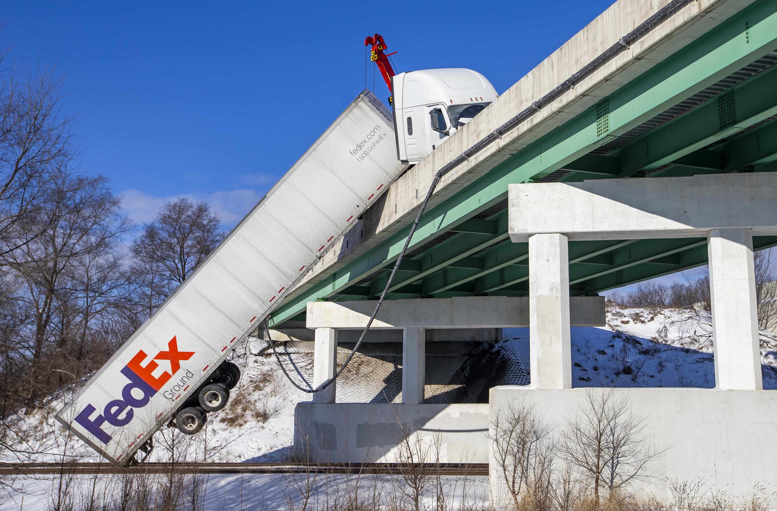 Slide-off leaves truck hanging from Indiana tollway overpass | AP News