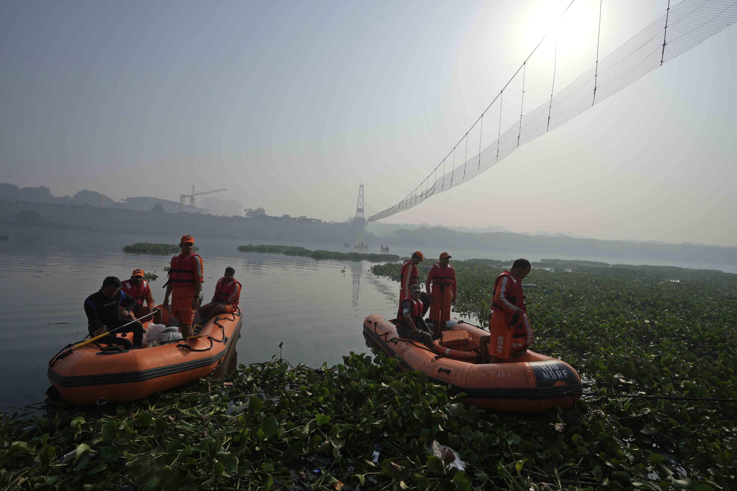 Officials probe India bridge collapse as divers comb river | AP News