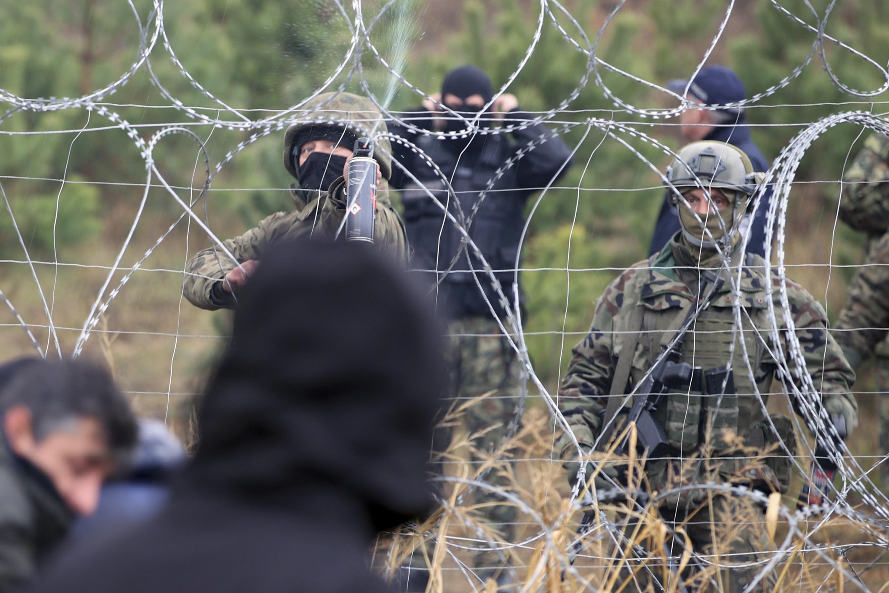 Migrants aided by Belarus try to storm border into Poland | AP News