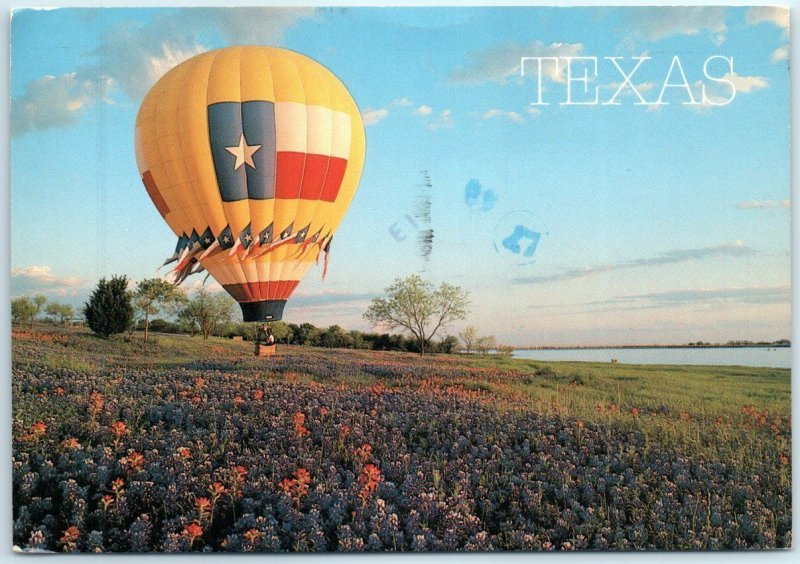 Hot Air Balloon with Texas state flag dips down into a field of ...