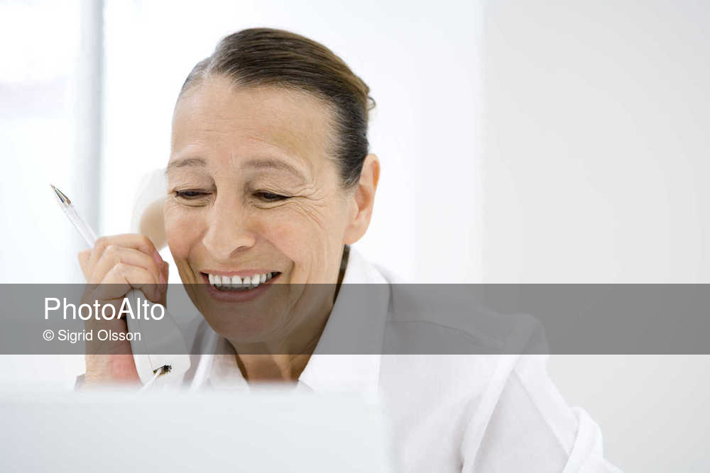 Senior woman using landline phone, smiling - Photoalto Senior woman using landline phone, smiling - Photoalto